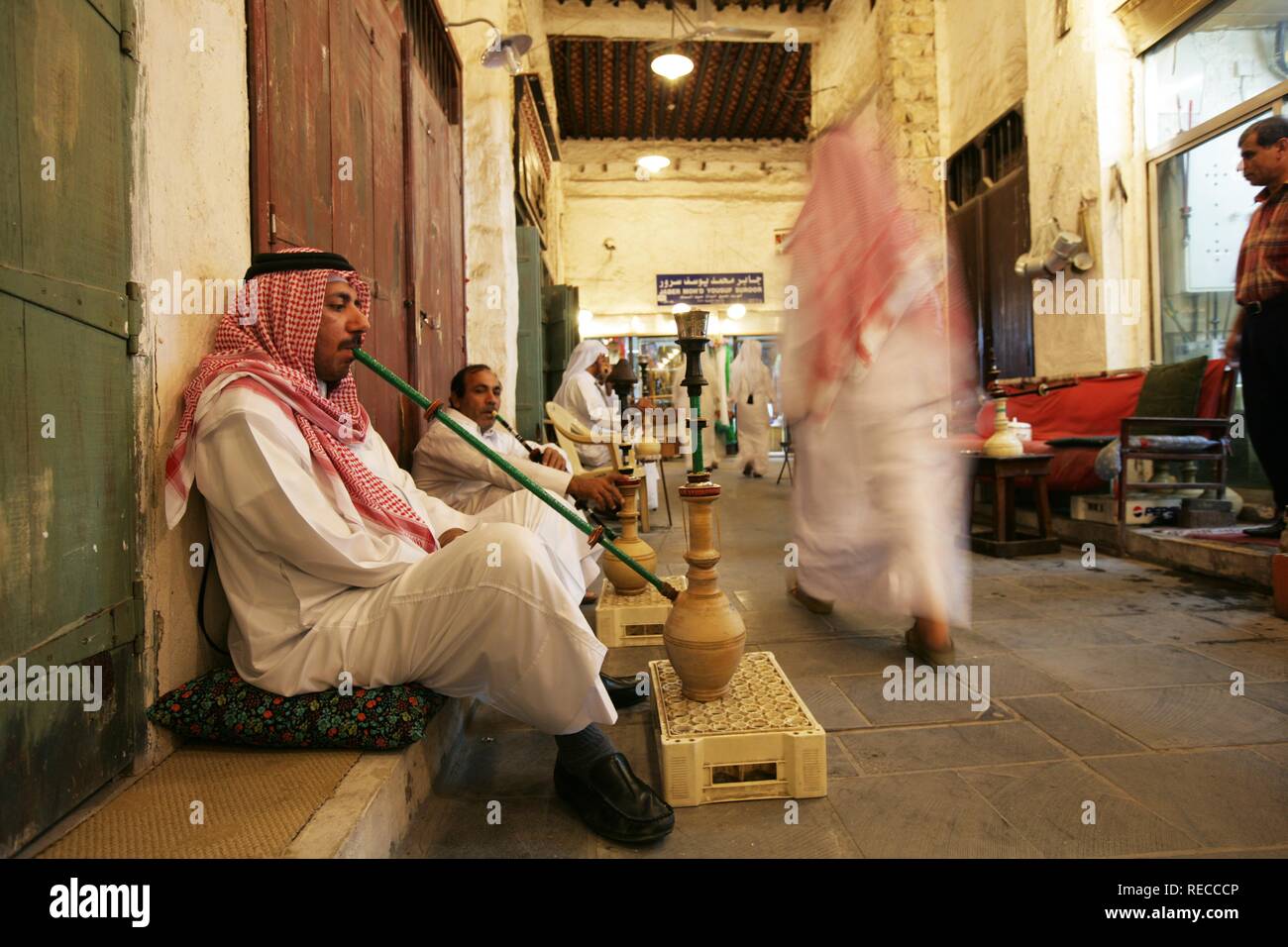 Men using a hookah or shisha in a cafe in Souq al Waqif market, the ...