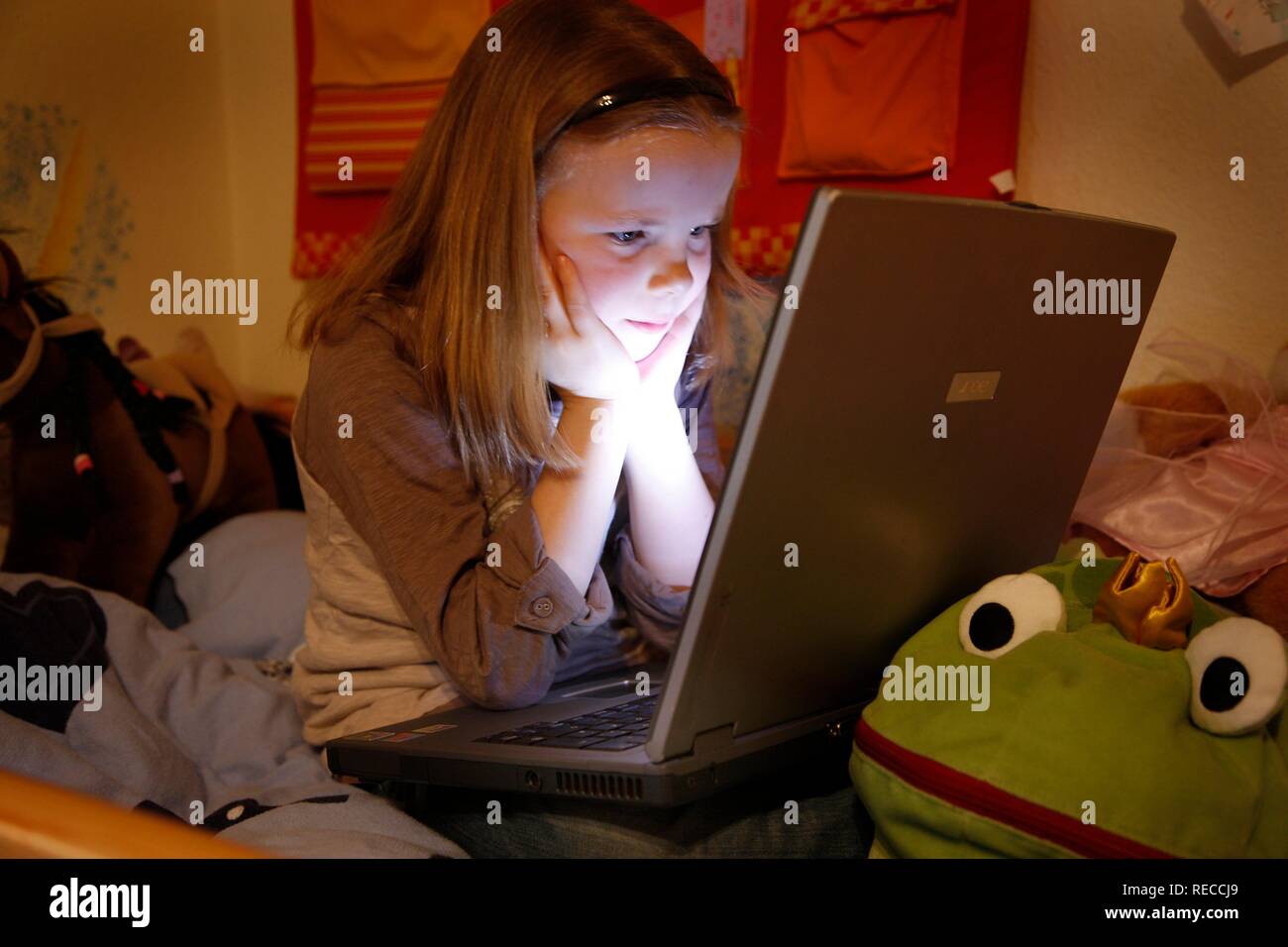 Girl, 7 years old, working with a computer at home in her room, sitting ...