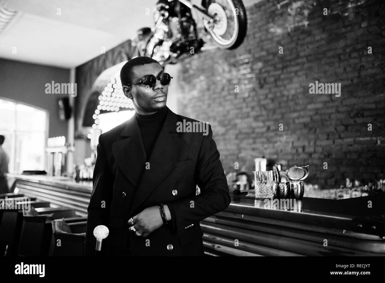 Stylish african american gentleman in elegant black jacket and sunglasses, holding retro walking ...