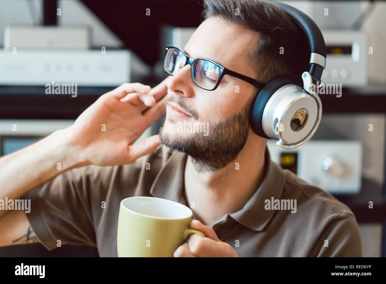Man drinking coffee and listening to music Stock Photo - Alamy