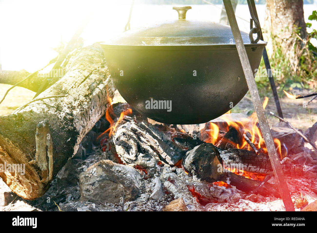 Big black pot on campfire Stock Photo - Alamy