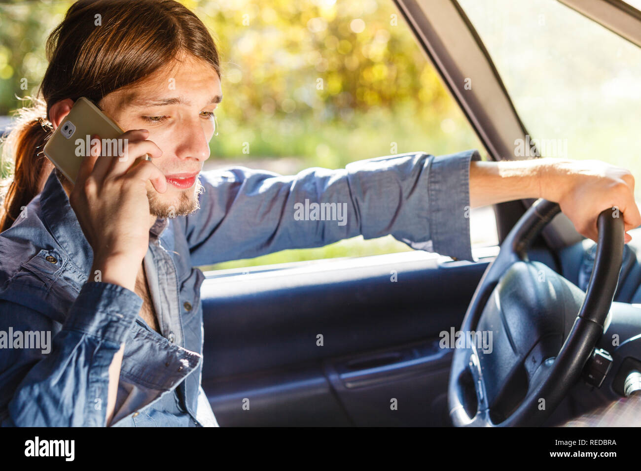 Talking while drive, danger fresh driver concept. Young man driving car ...