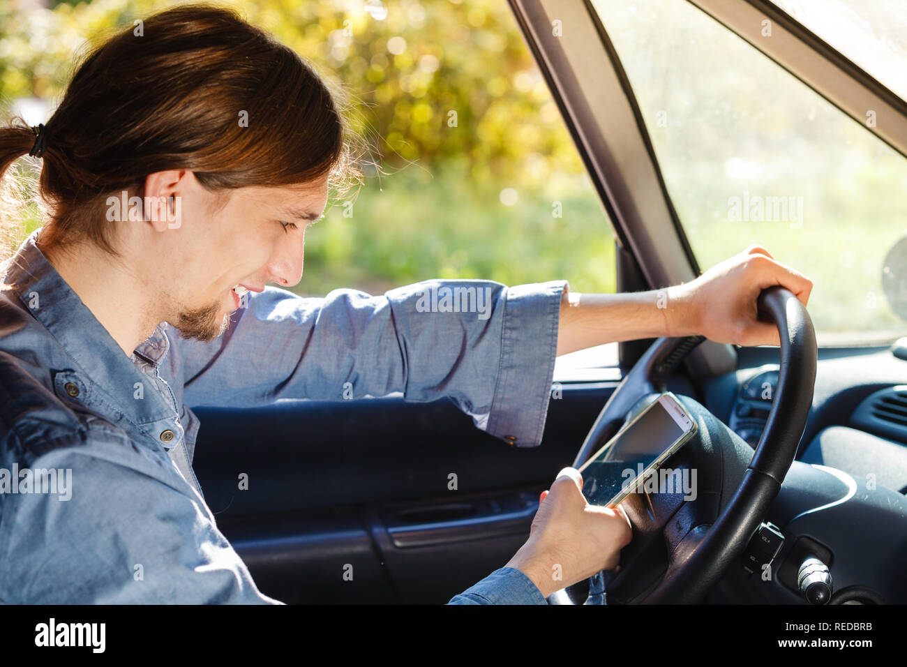 Modern technology concept. Man using mobile phone while driving car ...
