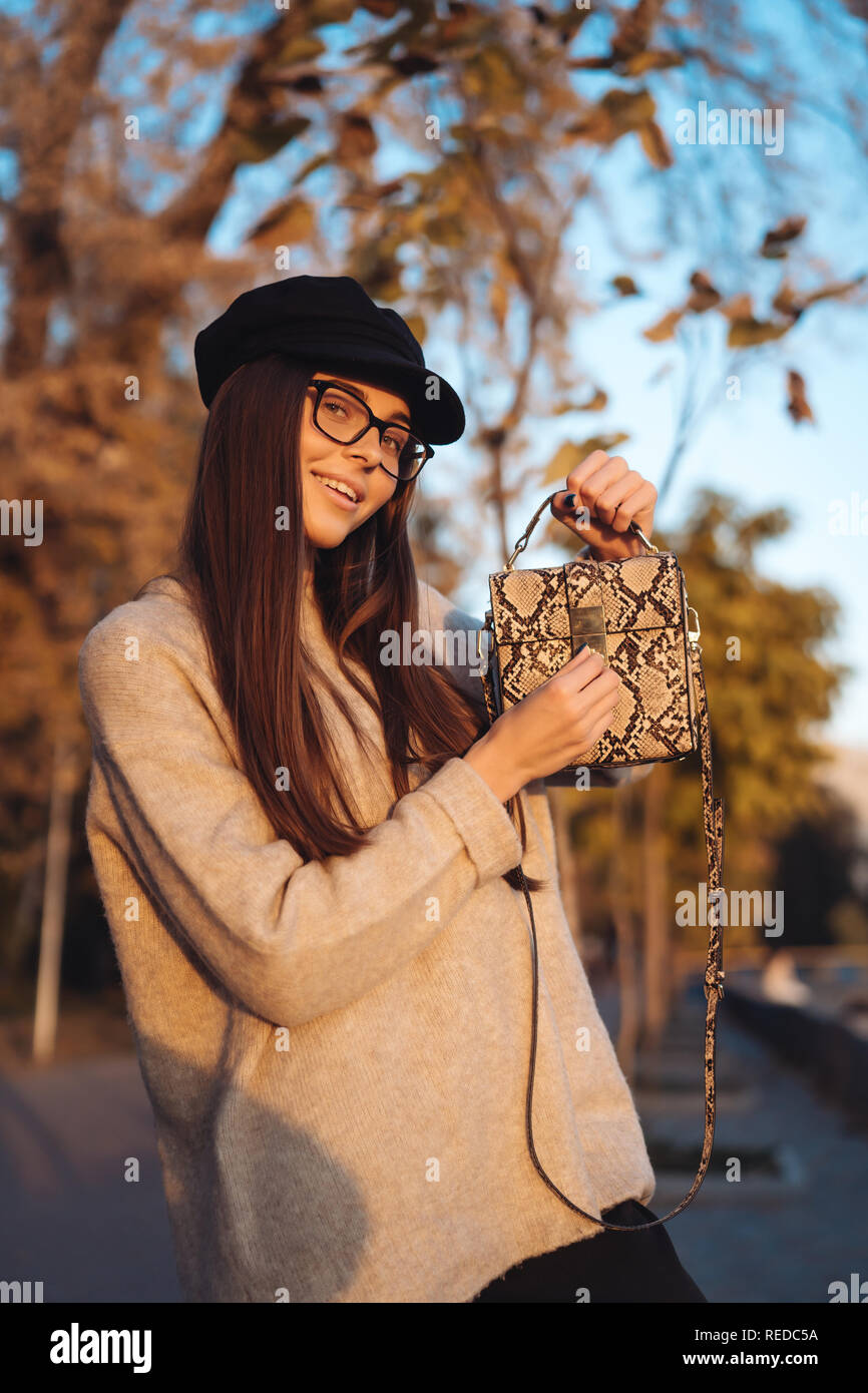 Beautiful young girl with handbag posing on camera Stock Photo - Alamy