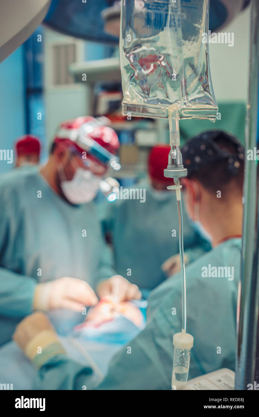 Dropper close-up on the background of the surgeon doing the operation ...