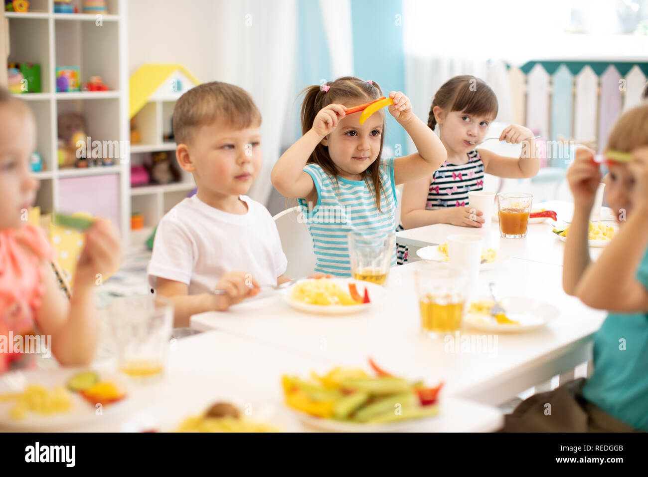 funny children eating vegetables in kindergarten or nursery Stock Photo ...