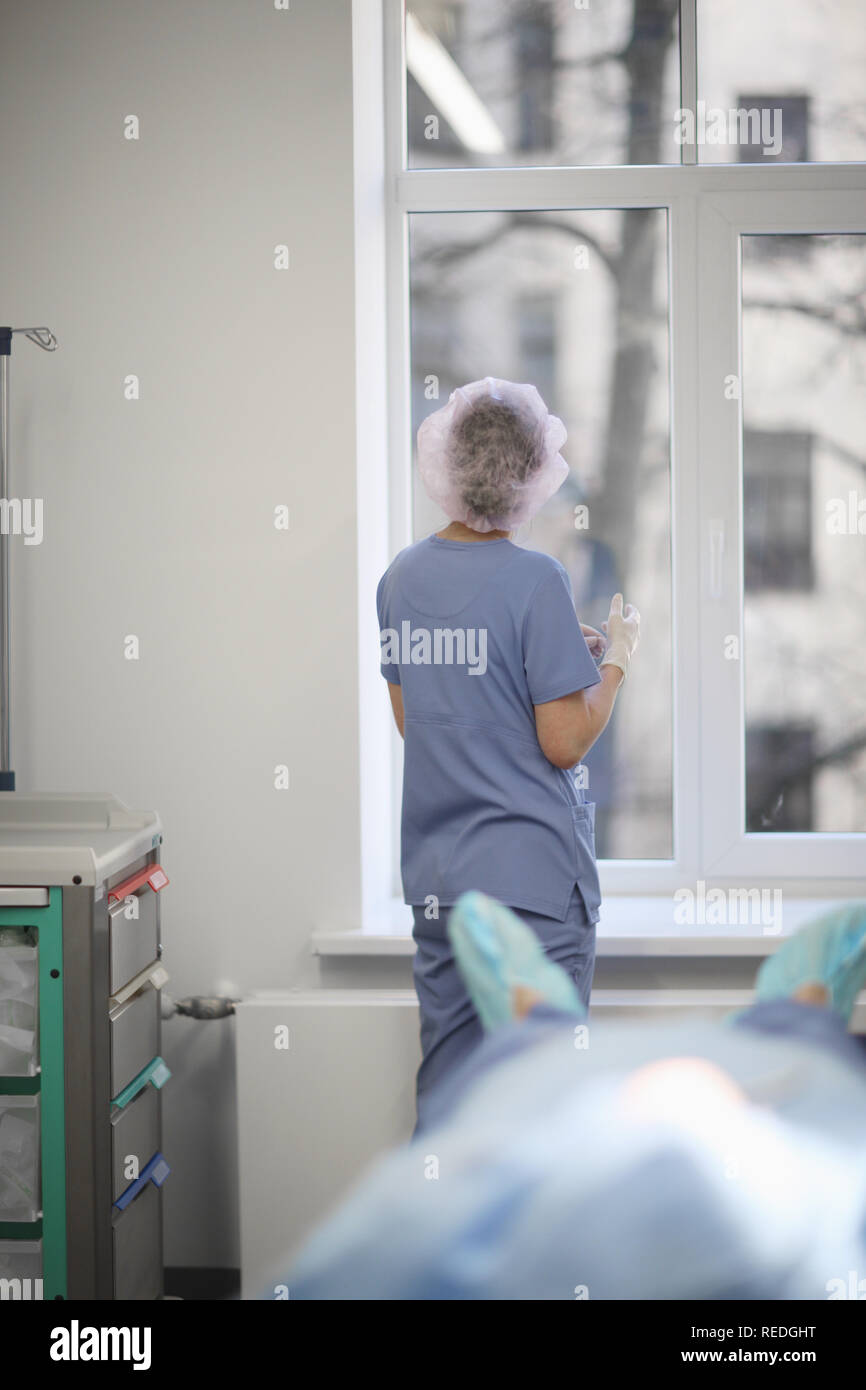 Doctor in uniform is standing by the window in the dental clinic Stock ...