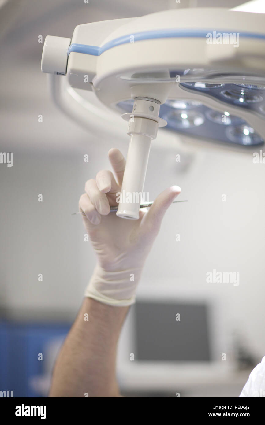 A doctor with a dental probe in his hand sets the drill light to work ...