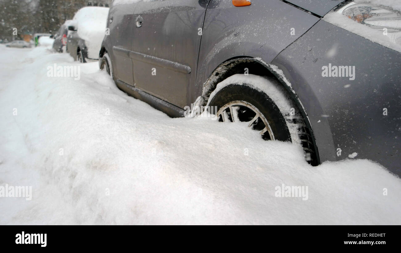 Wheel of car is stuck in snow. Car stranded in snow after a heavy ...