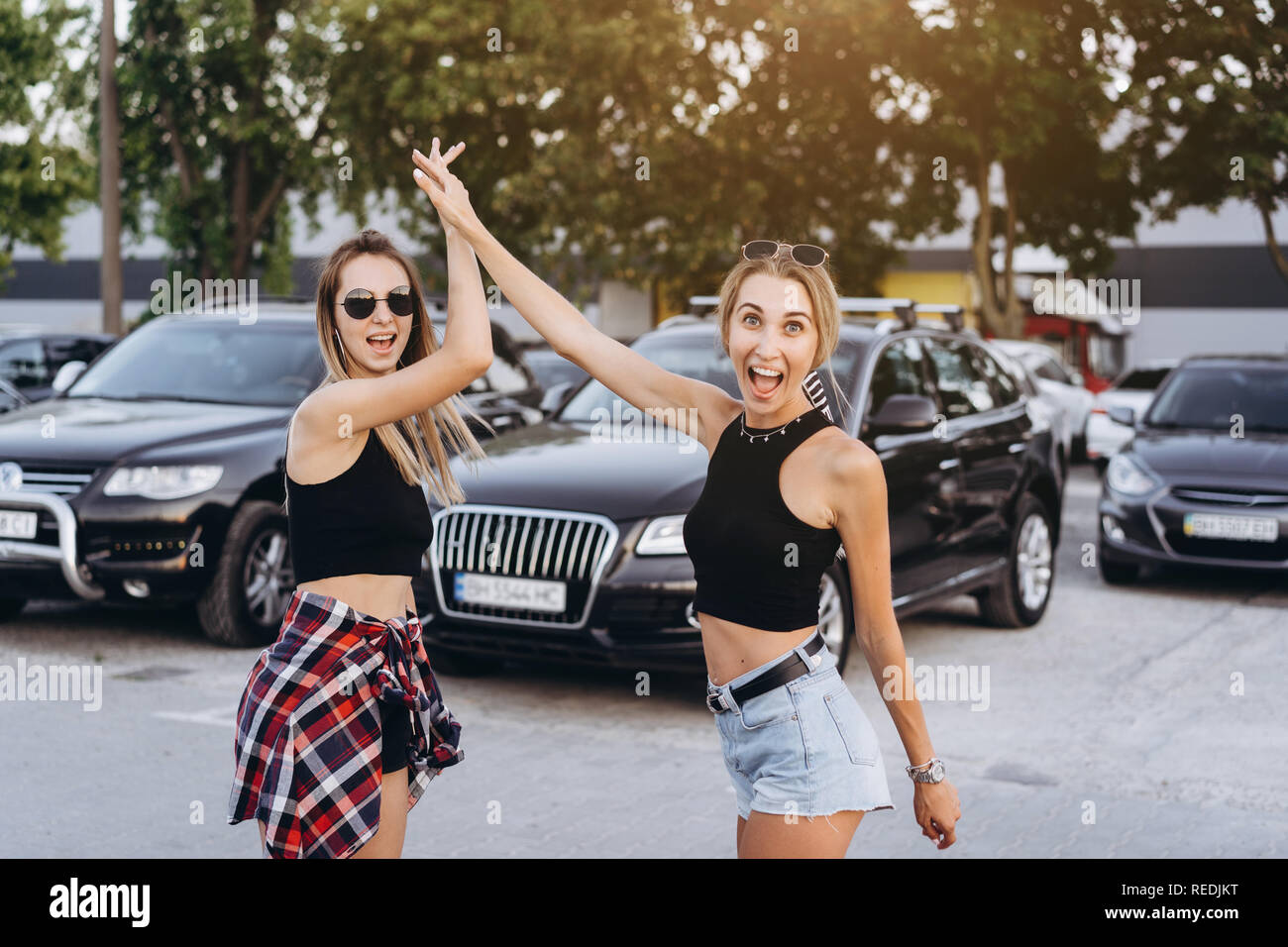 Two girls met in the car parking Stock Photo - Alamy
