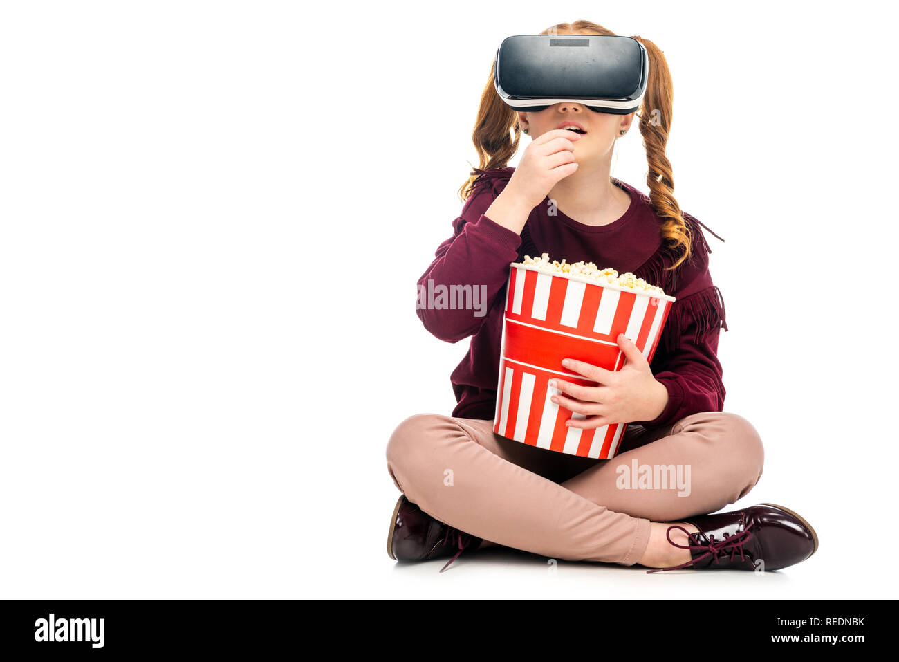 child with virtual reality headset on head holding striped bucket and ...