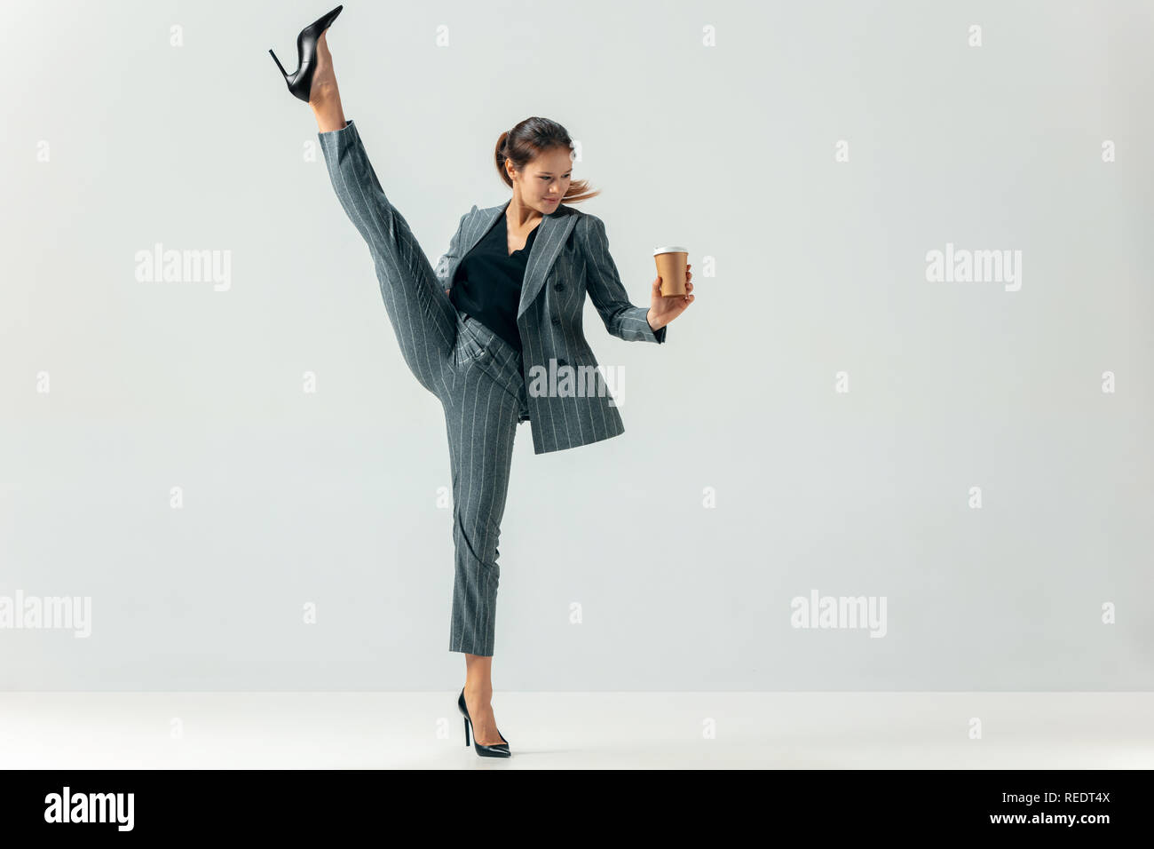 Happy business woman dancing and smiling in motion isolated over white ...