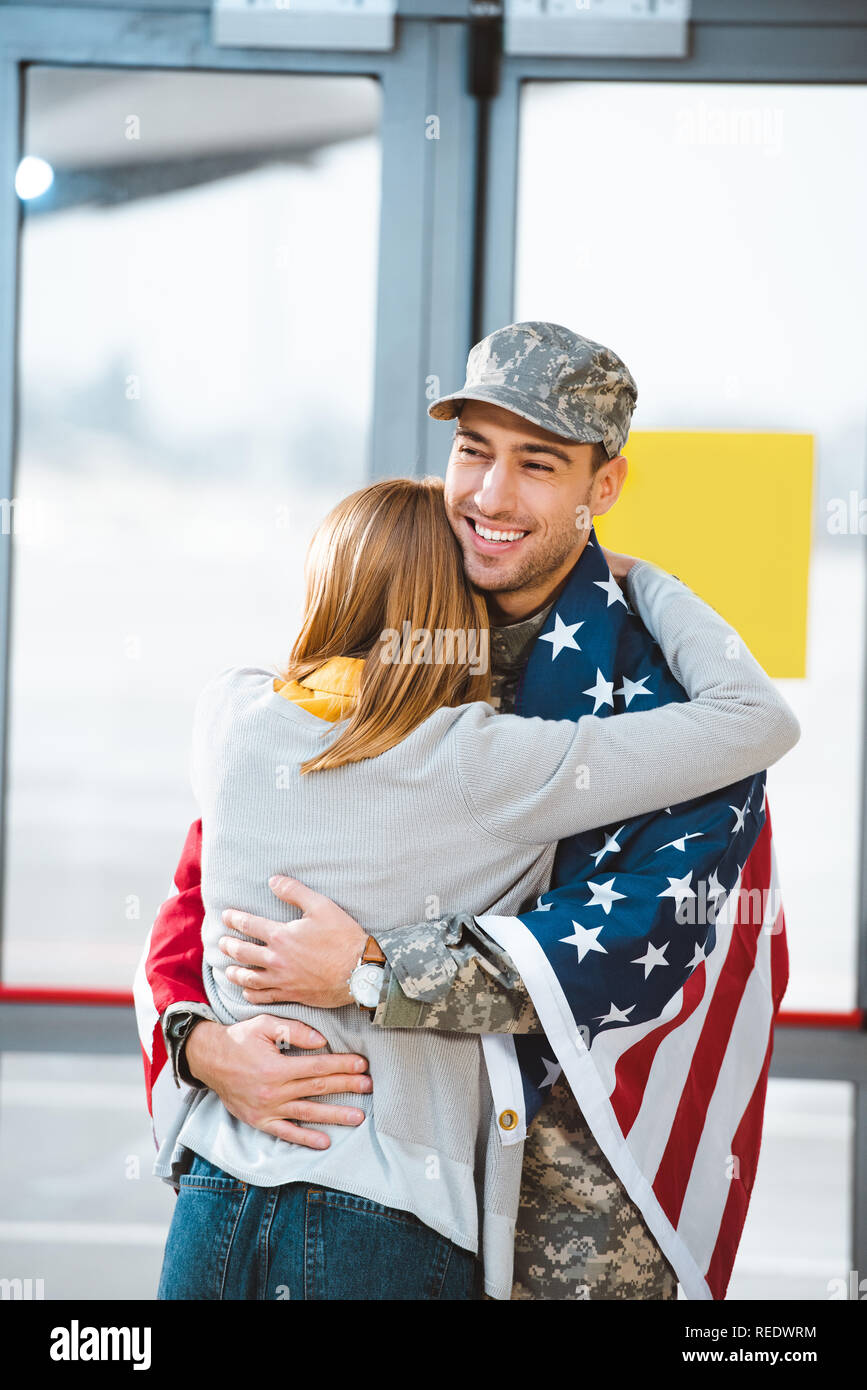 back view of woman hugging boyfriend in military uniform with american ...