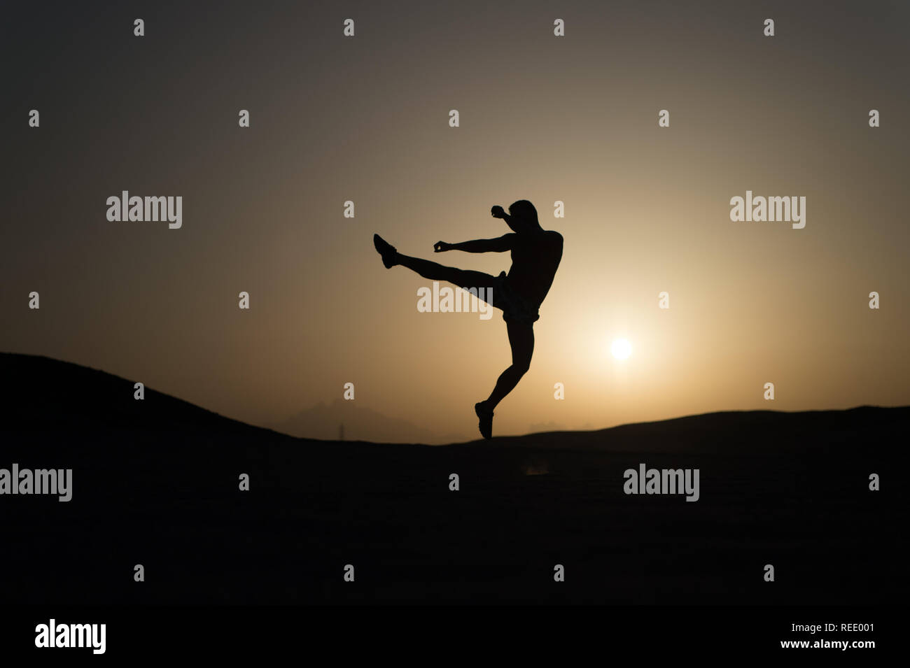 Hit your goal. Silhouette man motion jump in front of sunset sky ...