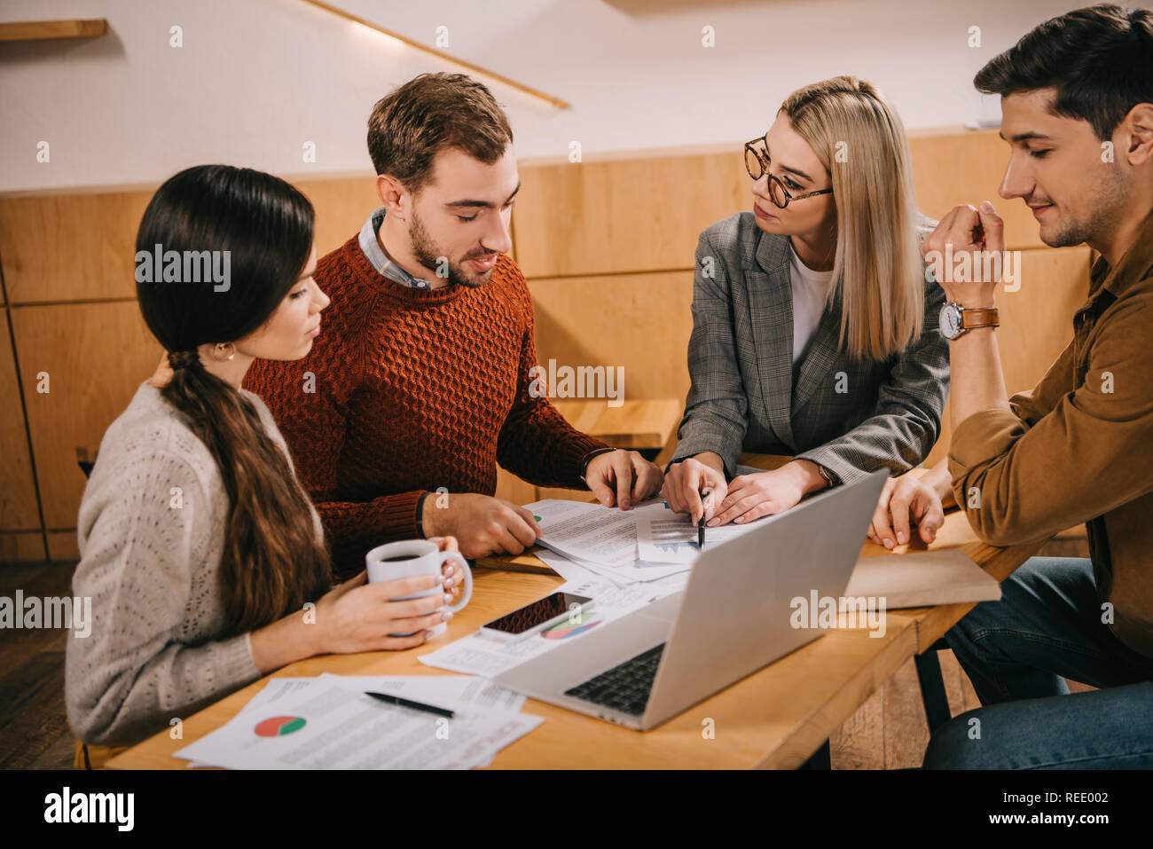 group of coworkers looking at charts and graphs in cafe Stock Photo - Alamy