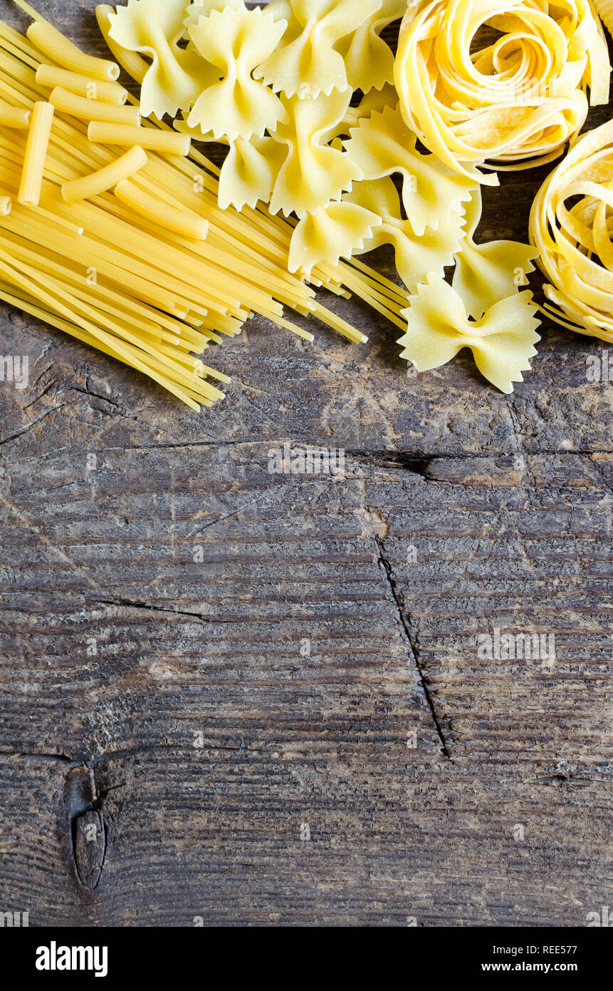 Variety of types and shapes of Italian pasta on old wooden background ...