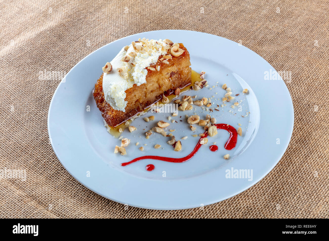 Turkish dessert ekmek kadayifi, bread pudding with cream on white Stock ...