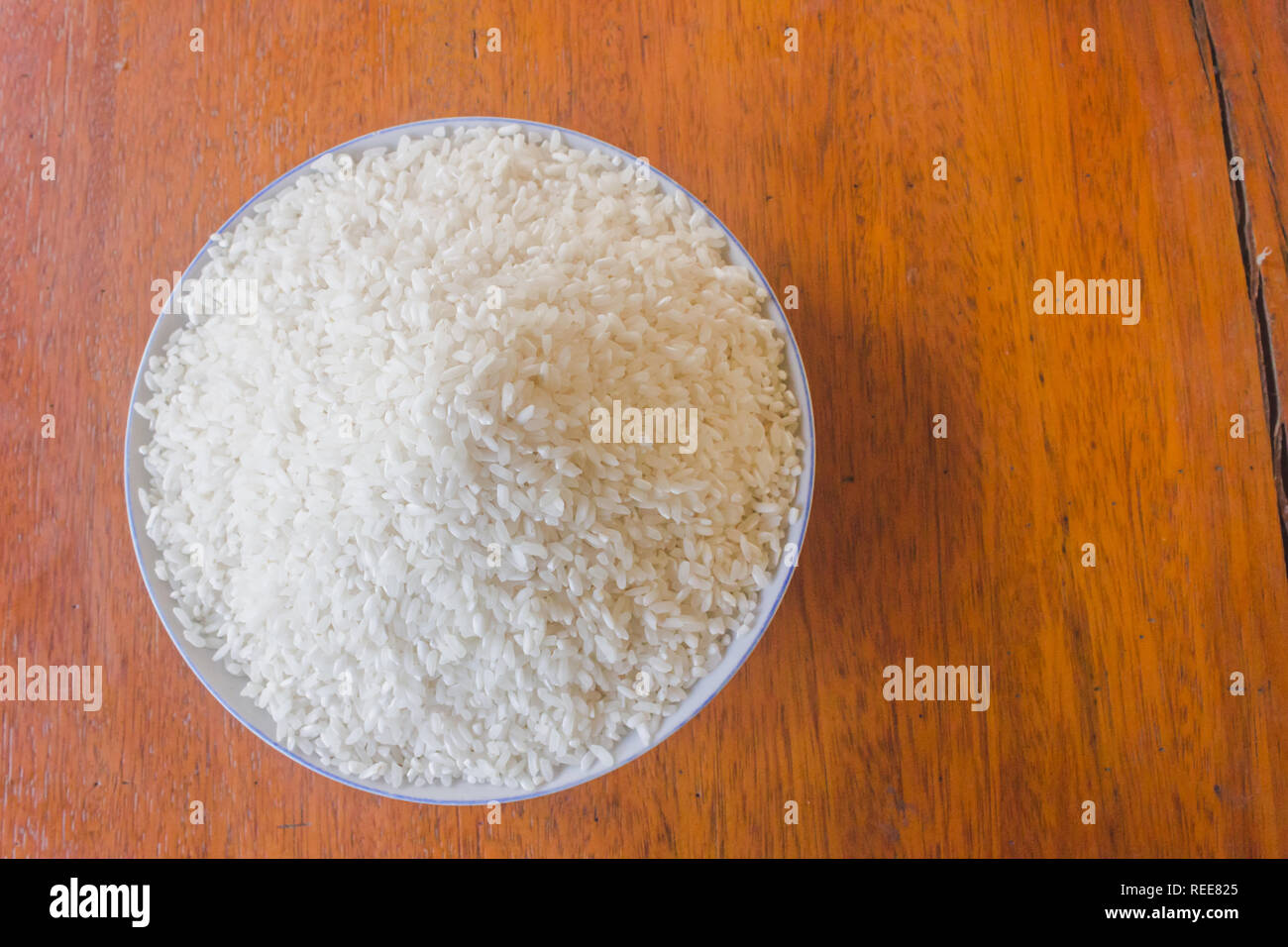Polished white rice in plate on top view close up with wooden table ...