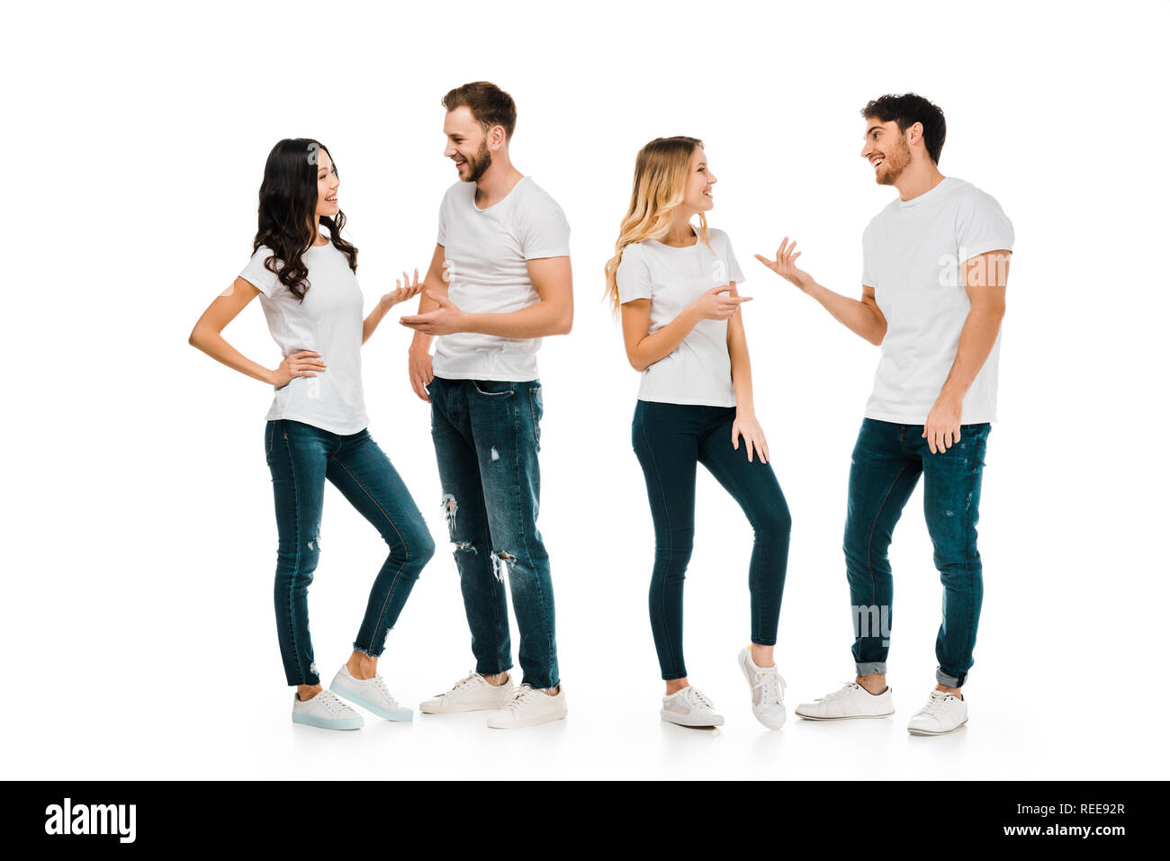 full length view of young couples standing and talking isolated on ...