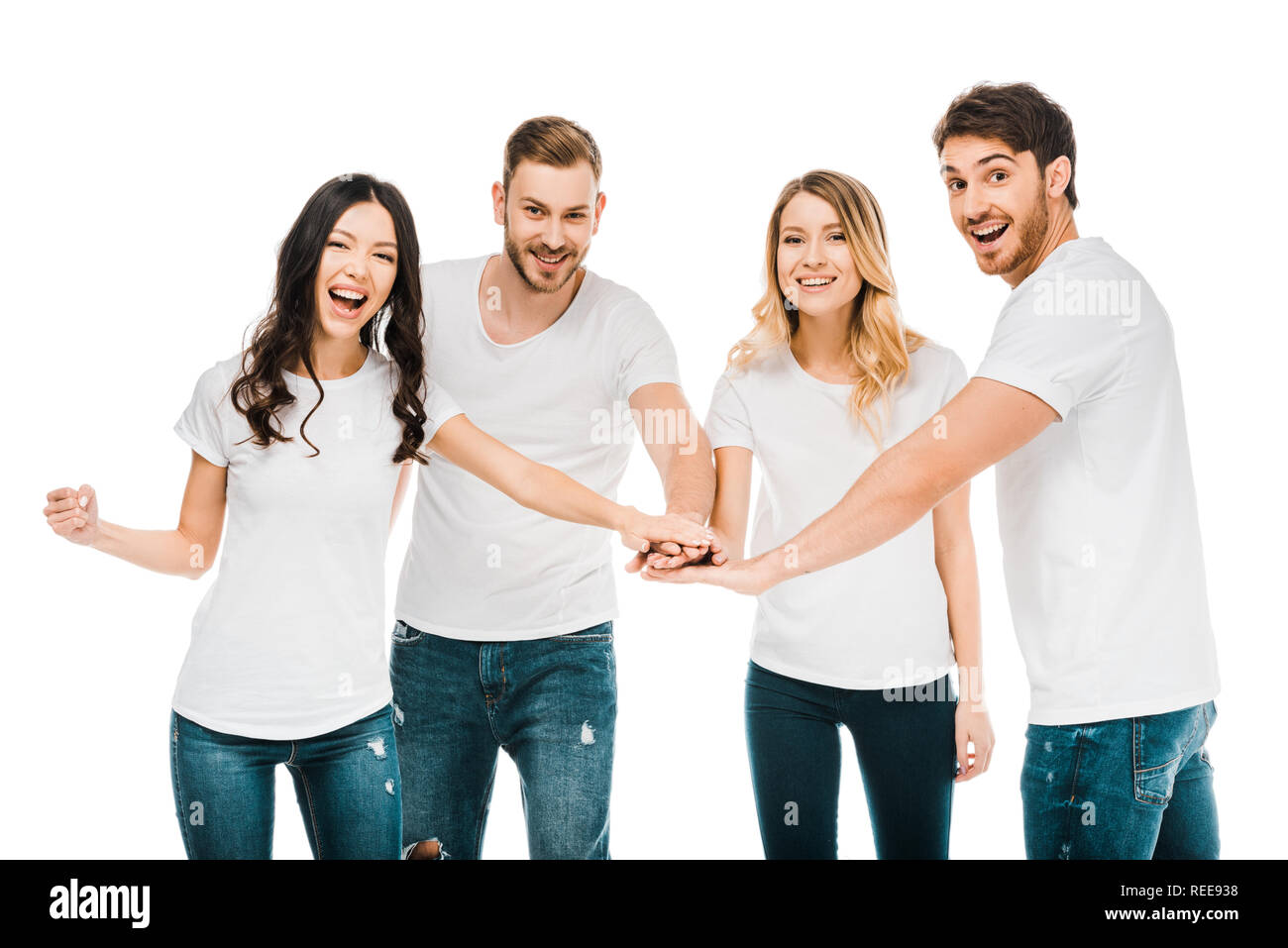 happy young friends stacking hands and smiling at camera isolated on ...