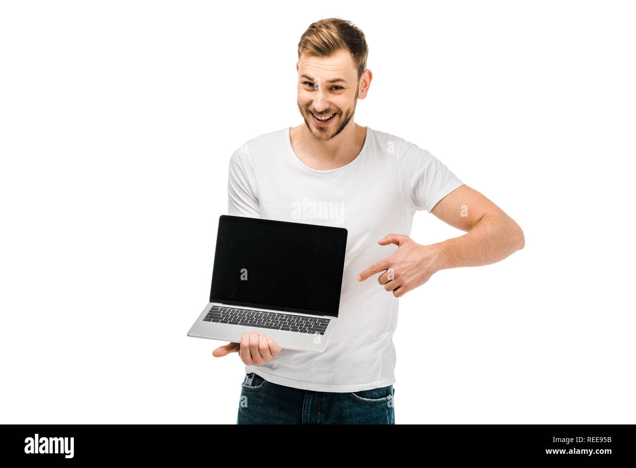happy young man pointing with finger at laptop with blank screen ...
