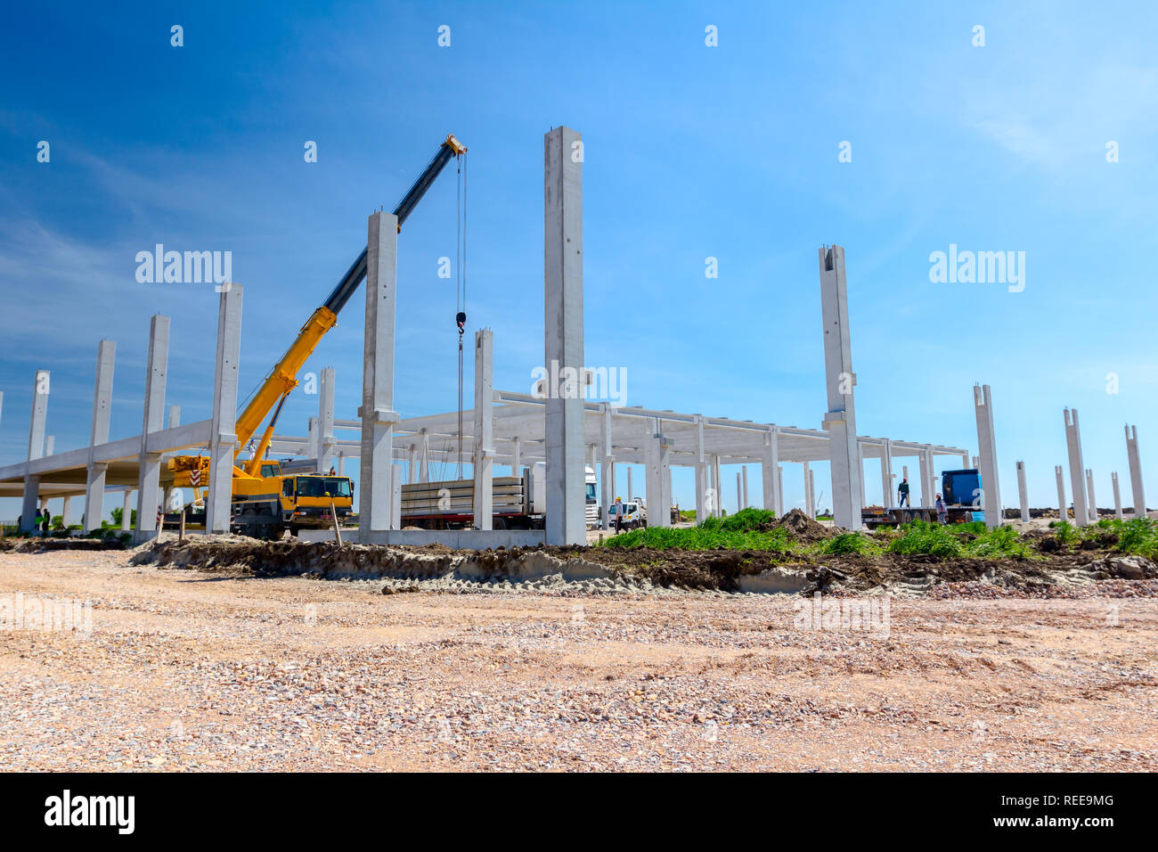 Mobile crane is assembly huge concrete skeleton of industrial building. Landscape transform into ...
