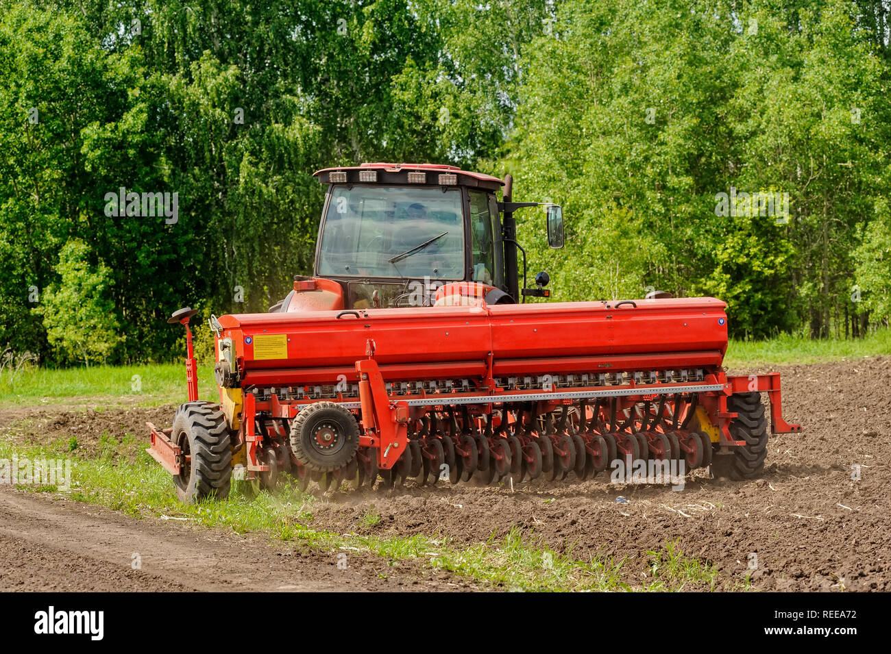 Agriculture tractor sowing seeds and cultivating field Stock Photo - Alamy