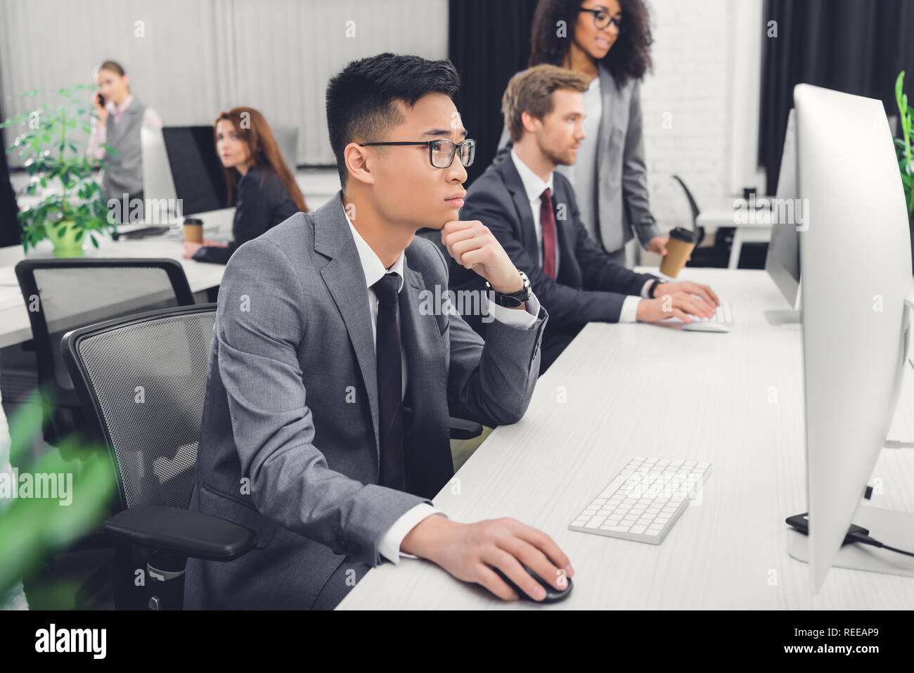 side view of focused business people using desktop computers in office ...
