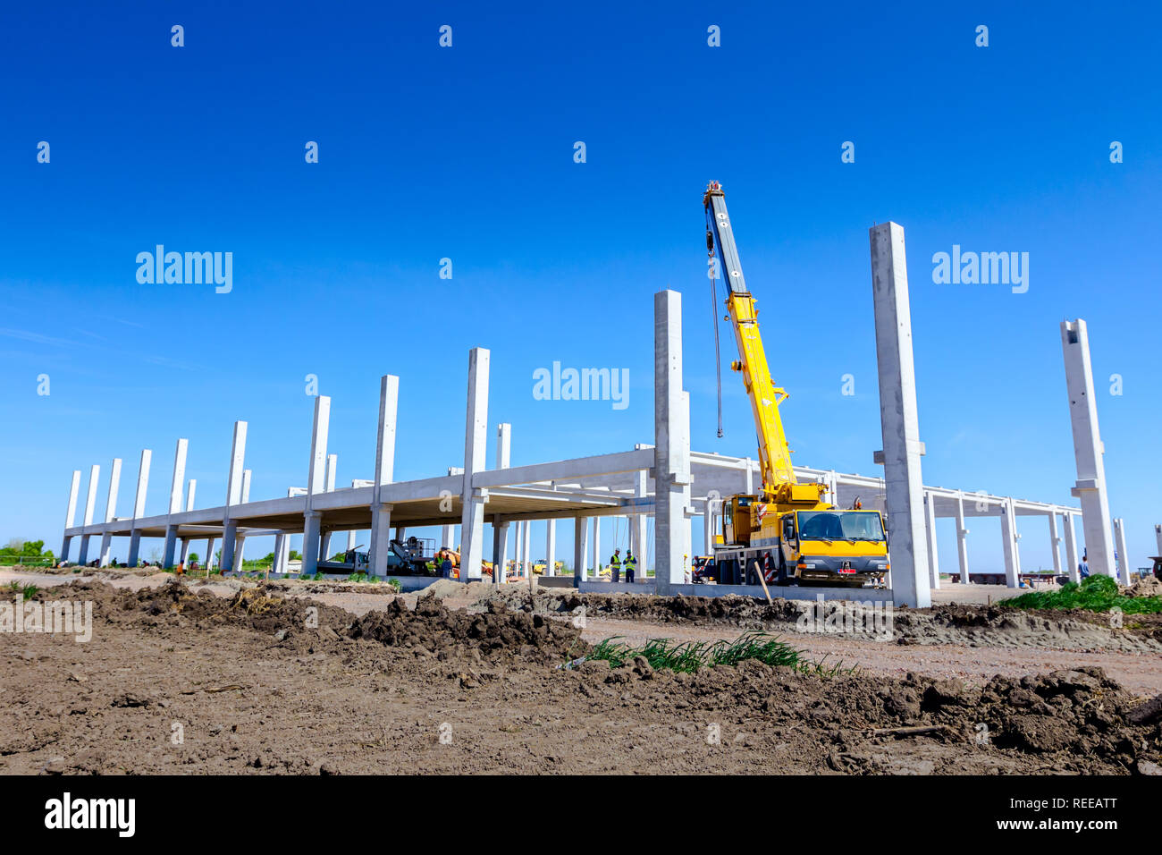Mobile crane is assembly huge concrete skeleton of industrial building ...