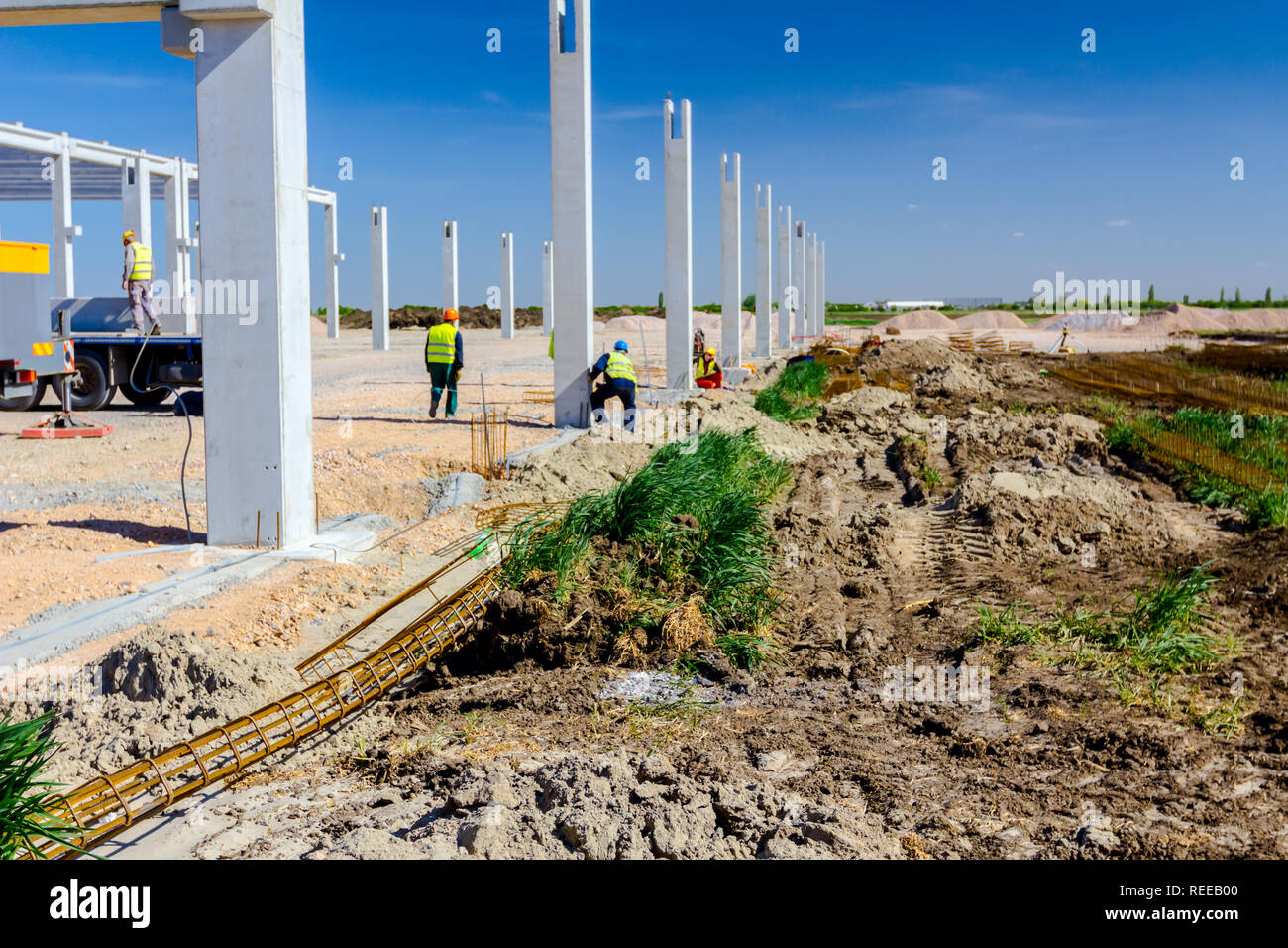 Group of construction workers with safety vests and yellow helmets, are ...