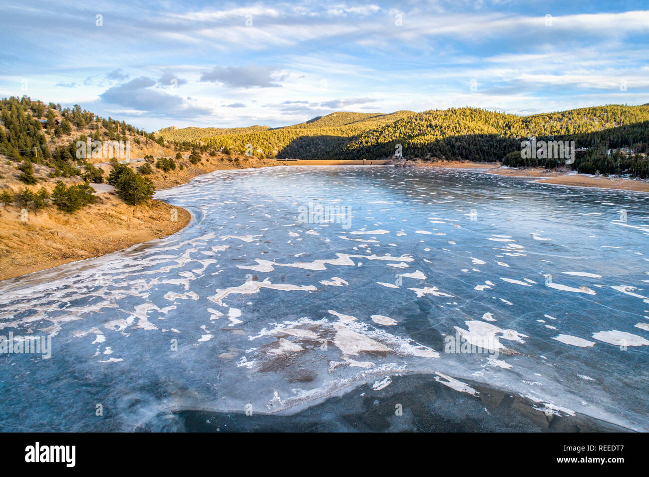 aerial view of a frozen shallow lake and a dam in Rocky Mountains ...