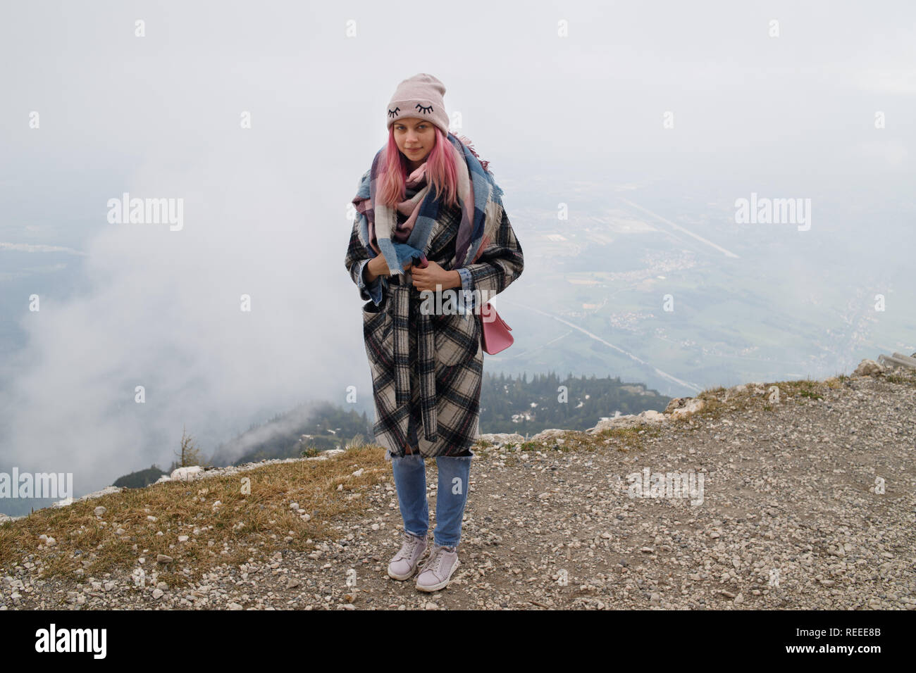 a young girl at the peak of misty mountain layout. Tourist traveler ...