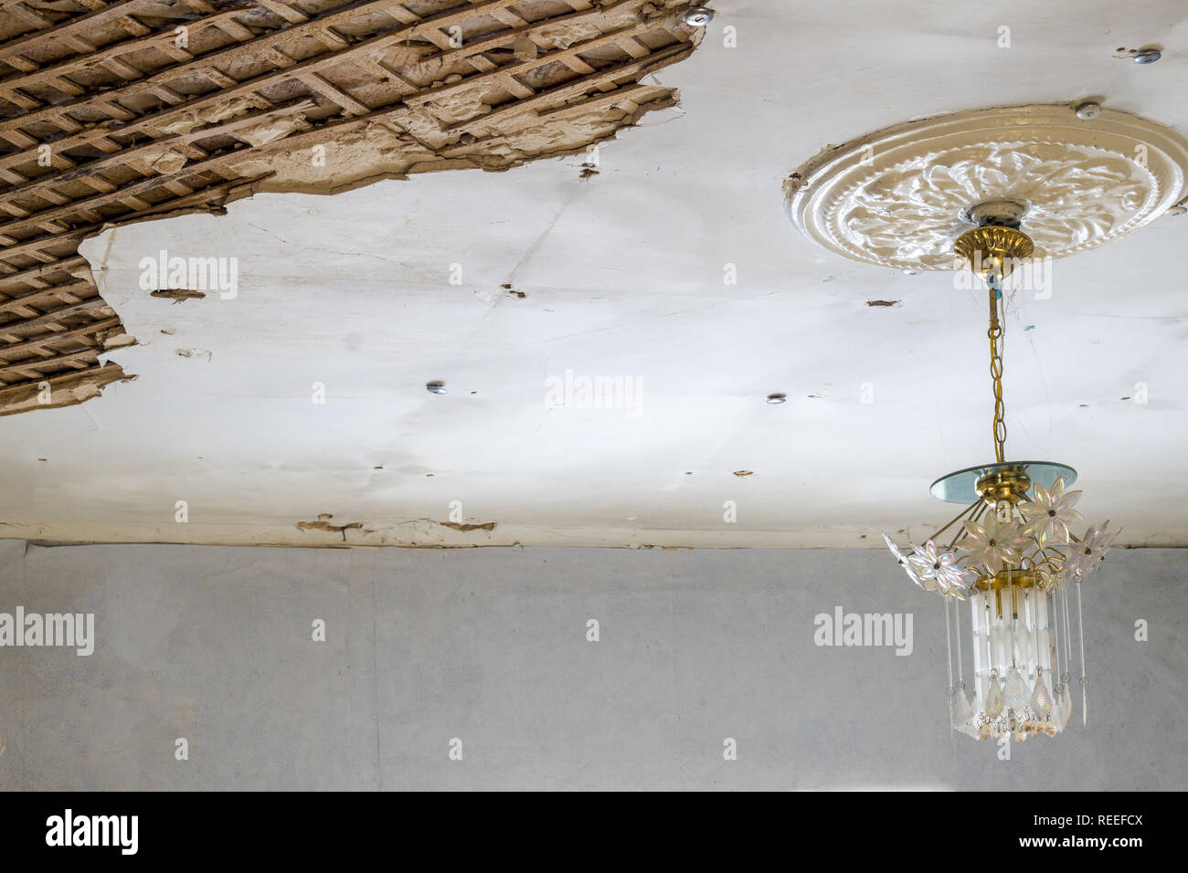 Ruined old ceiling and hanging lamp. Destroyed old ceiling before ...
