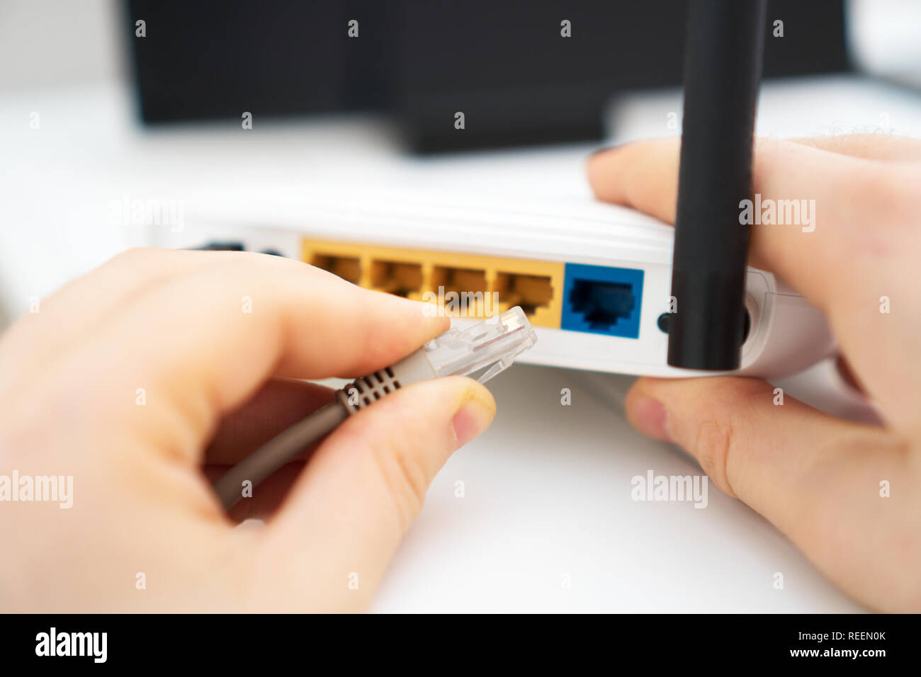 Man plugging internet cable into wifi router Stock Photo - Alamy