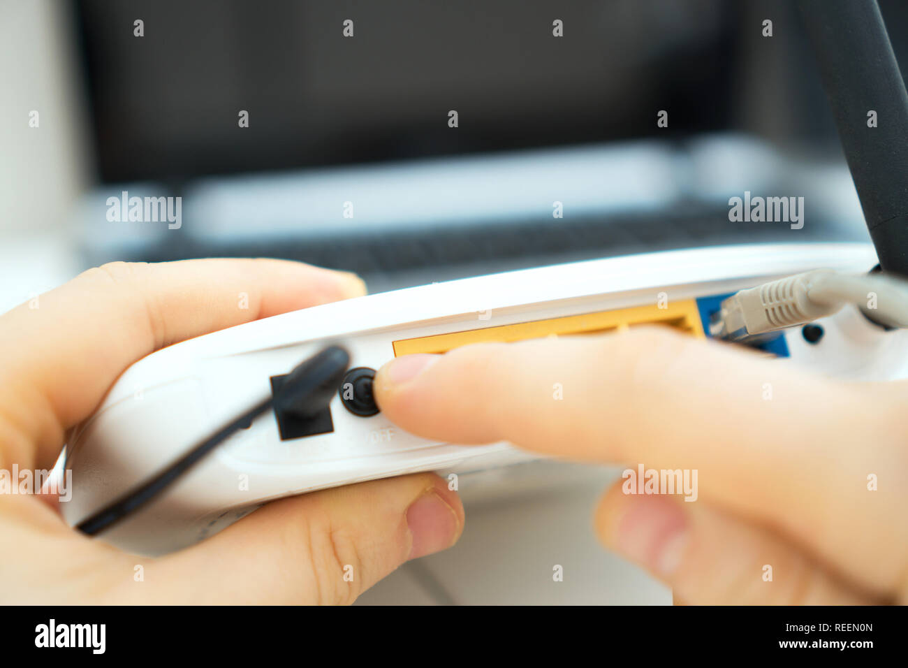 Man pressing power button on the wifi router Stock Photo - Alamy