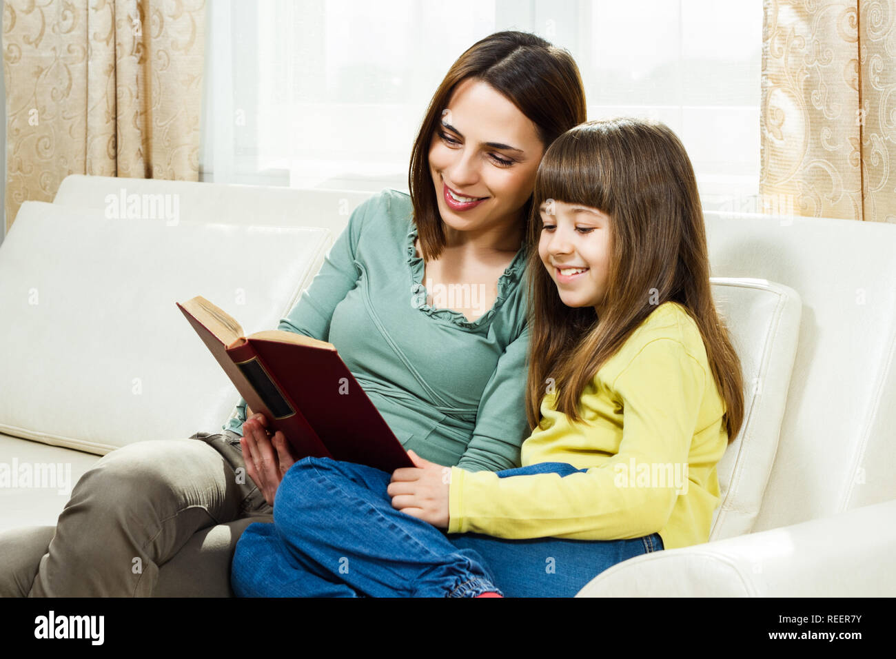 Mother and daughter reading book Stock Photo - Alamy