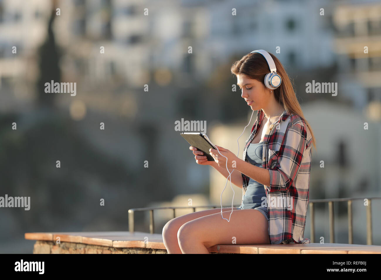 Side view portrait of a serious teenage girl e-learning using a tablet ...