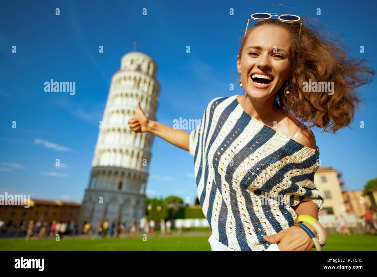 happy elegant woman in striped blouse near leaning tower in Pisa, Italy ...