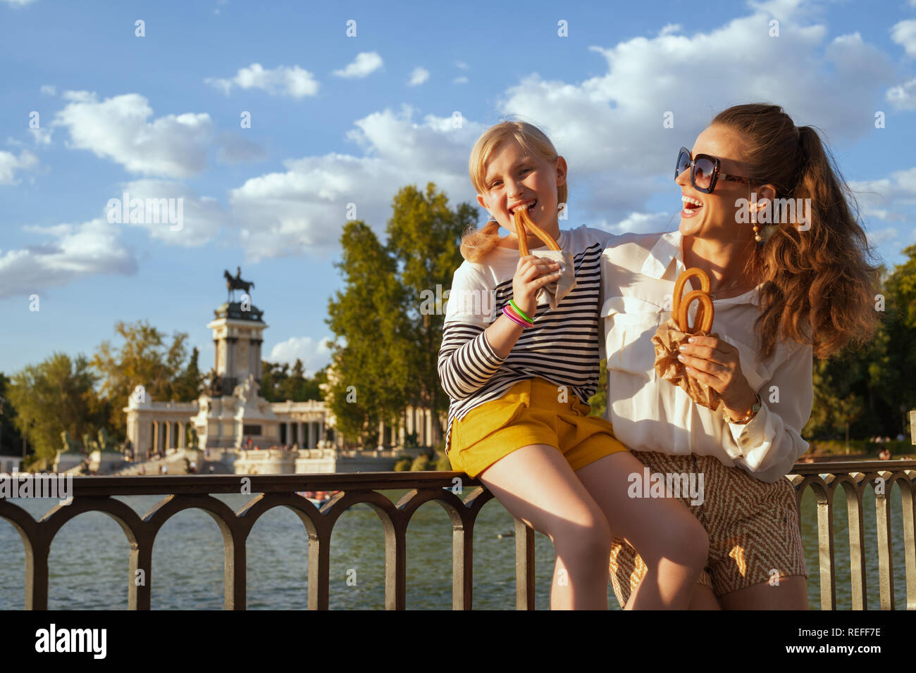 happy trendy mother and child tourists at Buen Retiro Park in Madrid ...