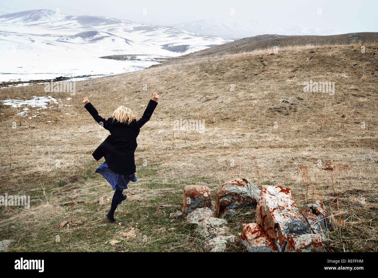 Woman running away in the snow landscape Stock Photo - Alamy