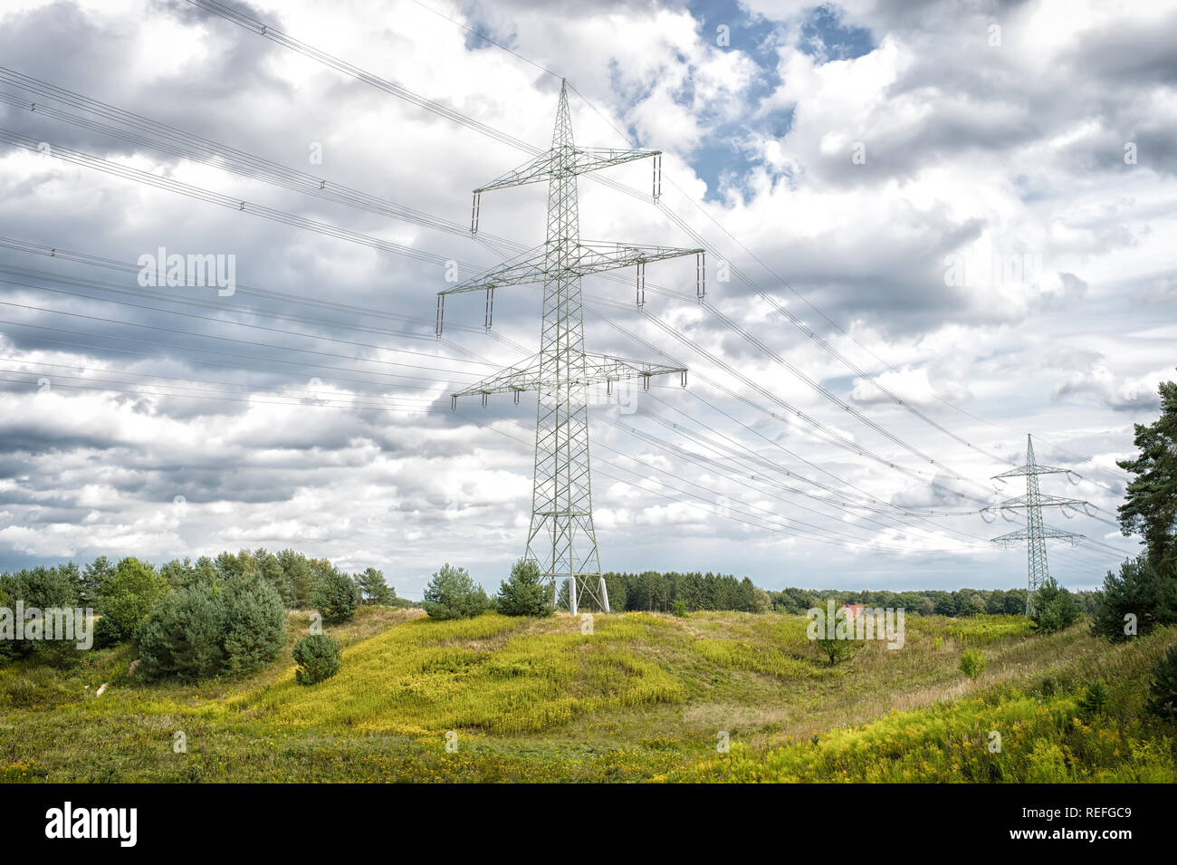 Power towers on natural landscape. Transmission towers on cloudy sky ...