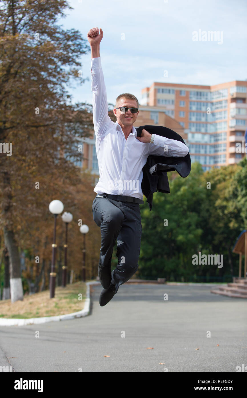 Happy man jump on street. Businessman celebrate victory on cityscape ...