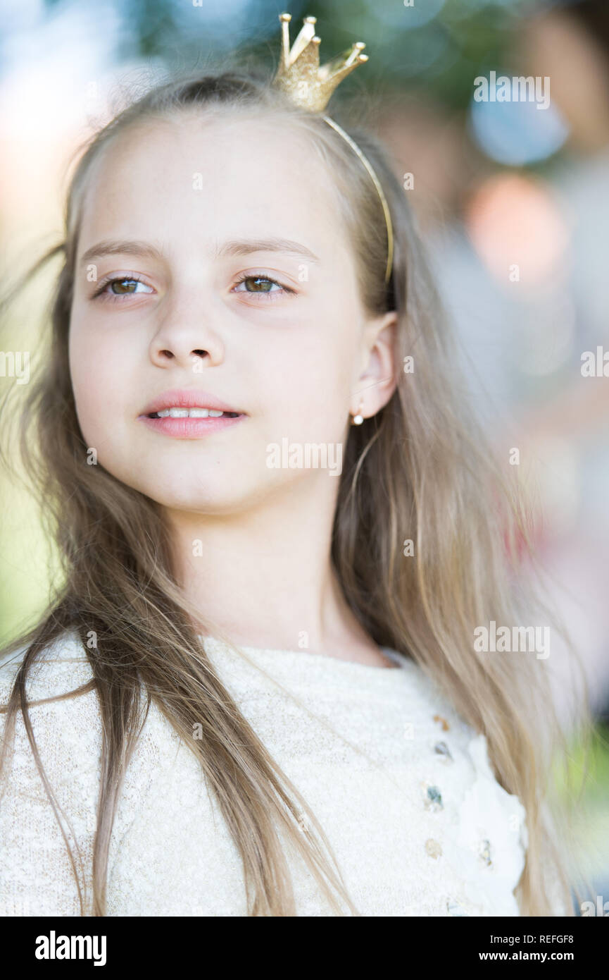 Girl kid on calm face with tiny golden crown on head, nature background ...