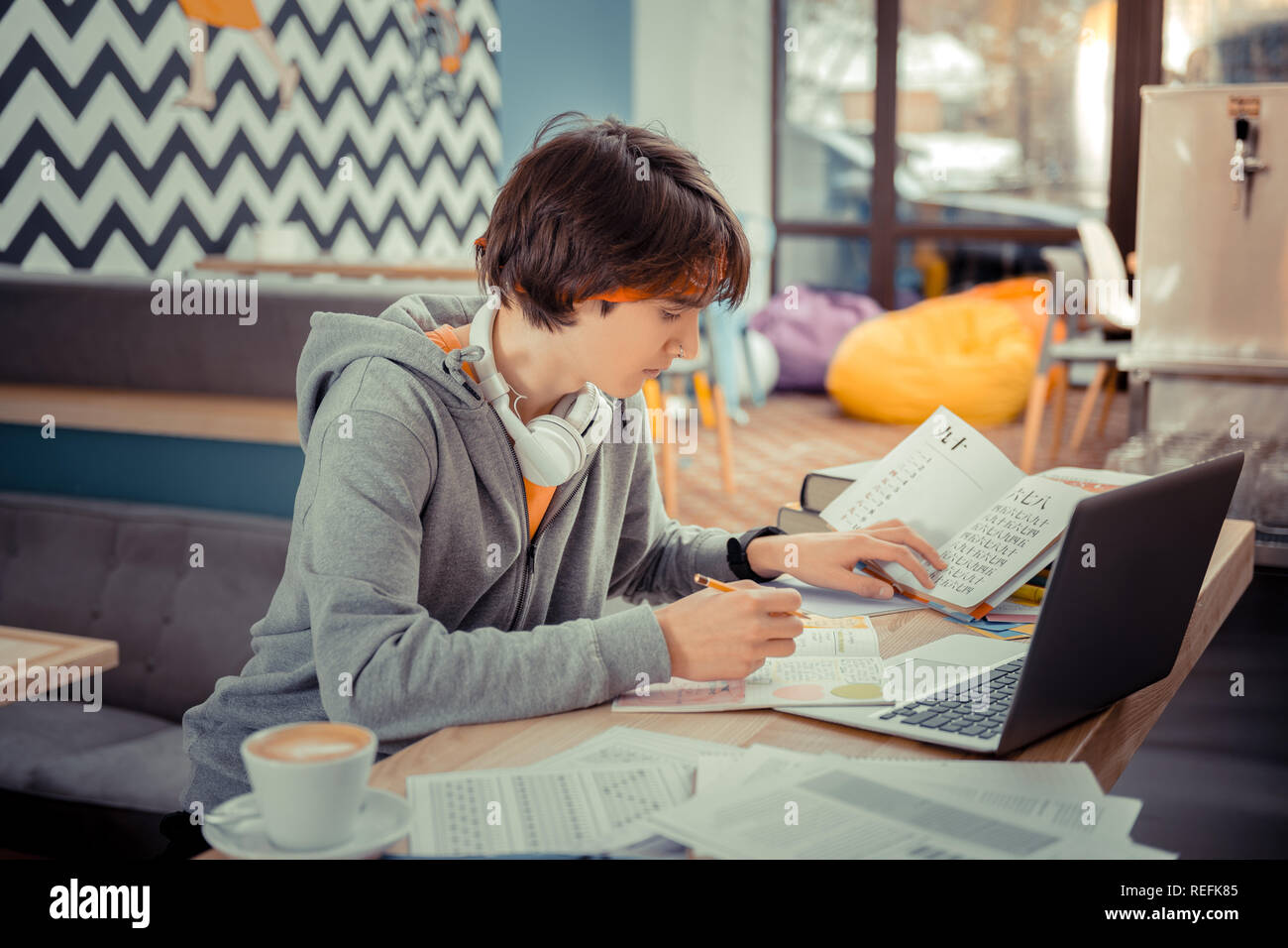 Student concentratedly writing his own research project Stock Photo - Alamy