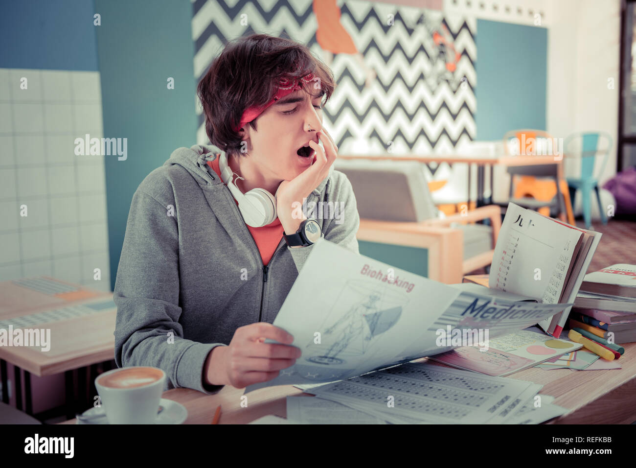 Student feels sleepy while doing a lot of homework Stock Photo - Alamy
