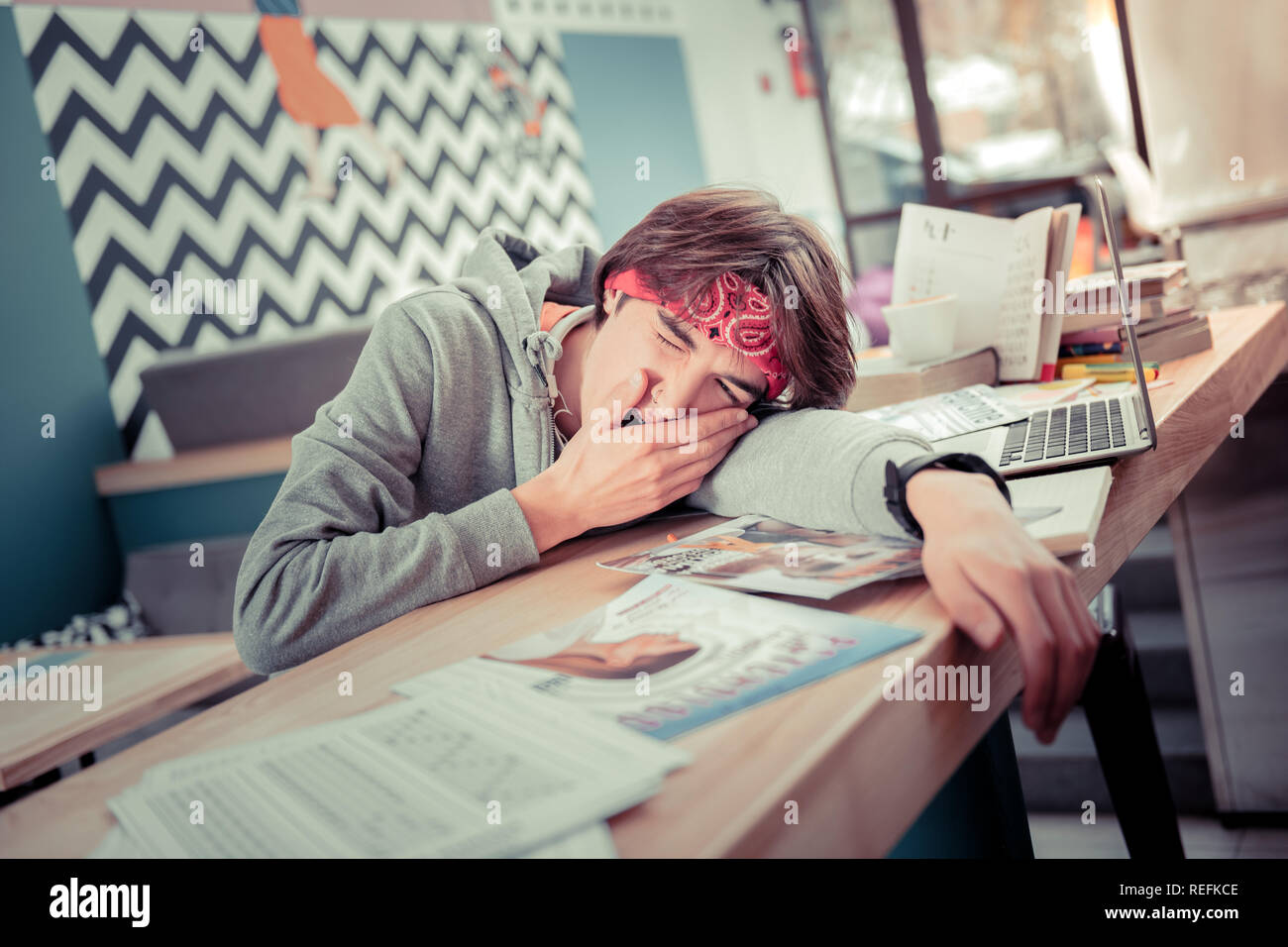 Tired student yawning and lying on the table Stock Photo - Alamy