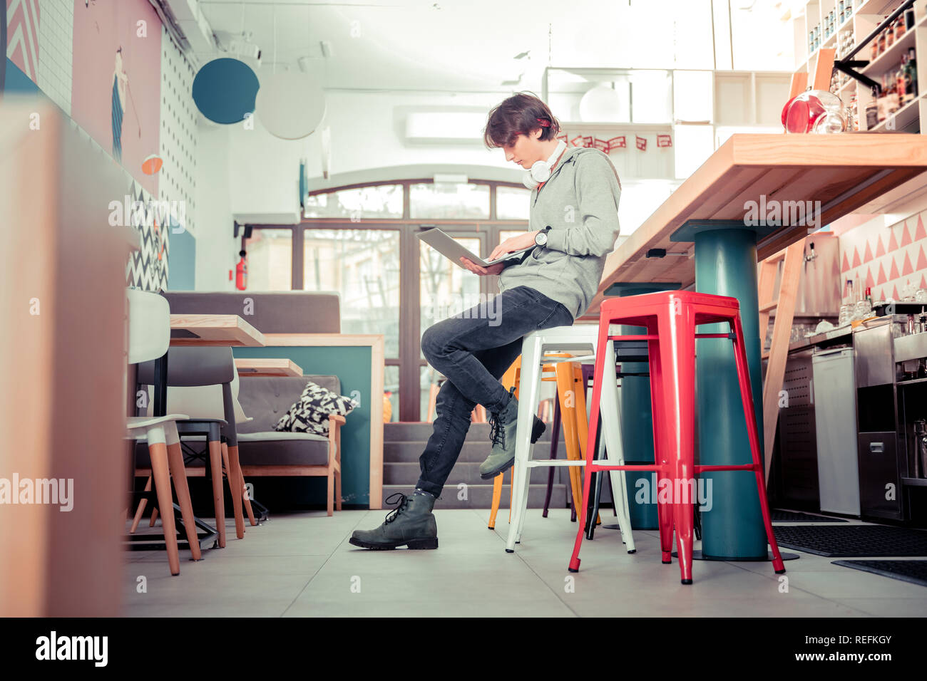 Junior programmer working in his favourite cosy cafe Stock Photo - Alamy
