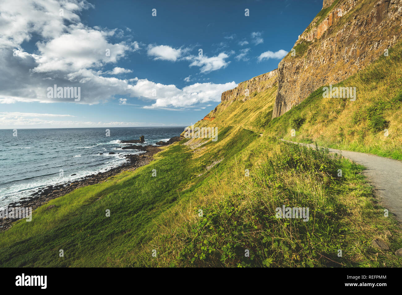 Steep green slope with tourist path. Northern Ireland. The grass ...