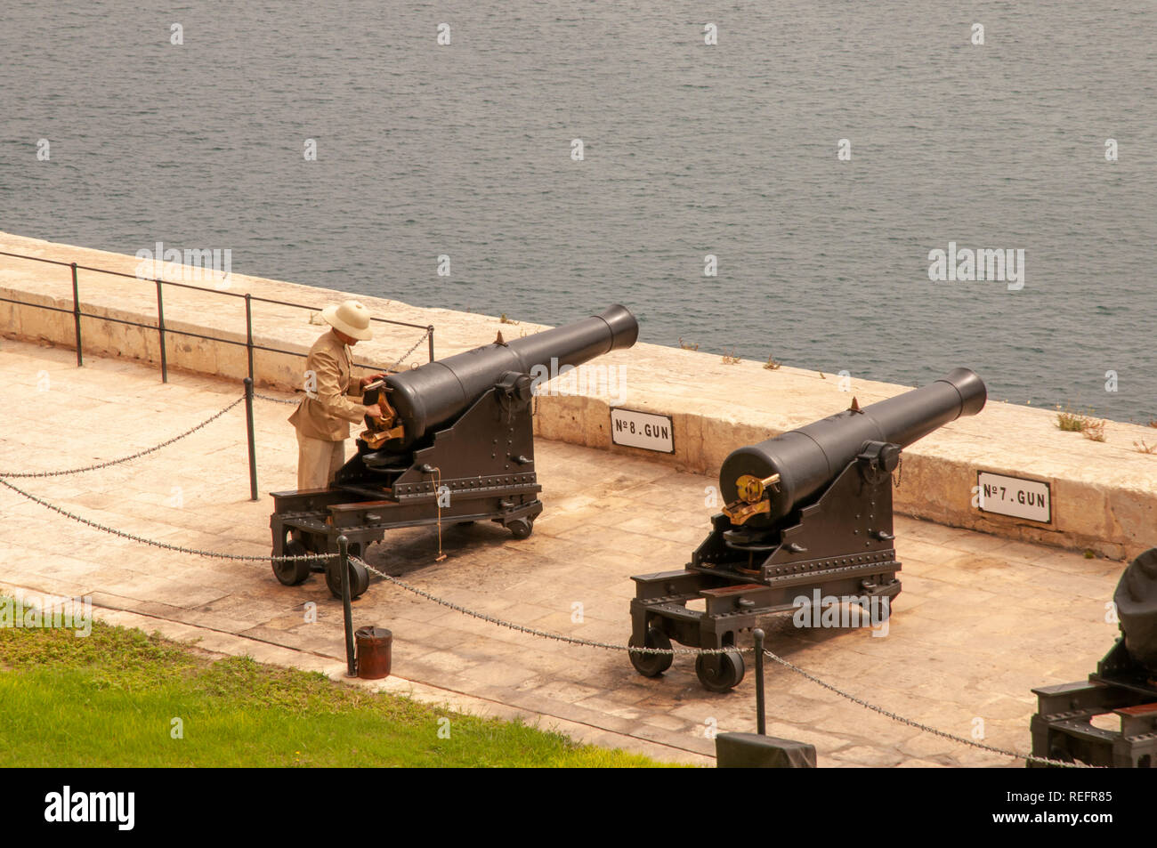Soldier loading two old bronze cannons for the midday salute at the ...