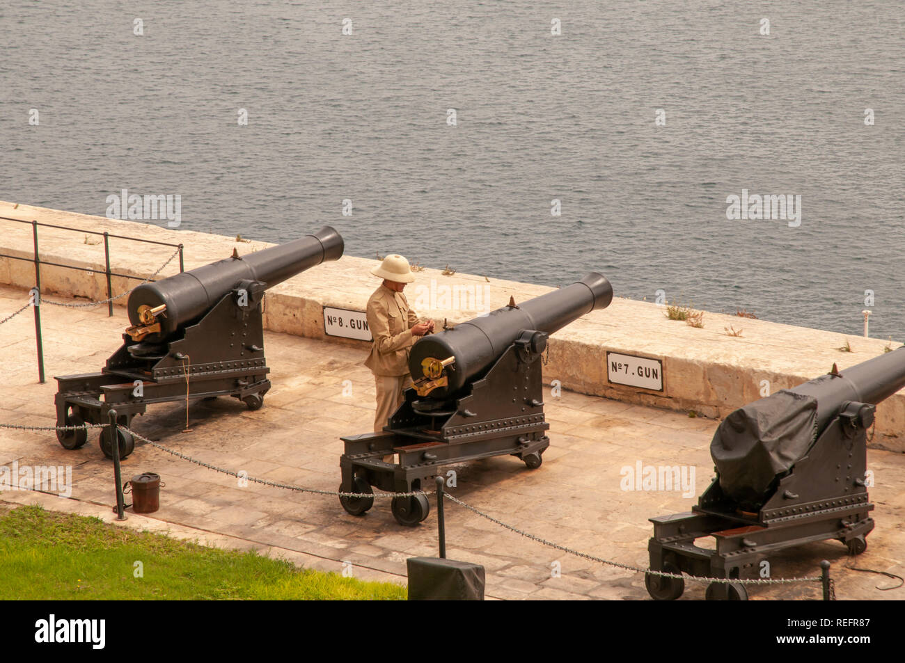 Soldier loading two old bronze cannons for the midday salute at the ...